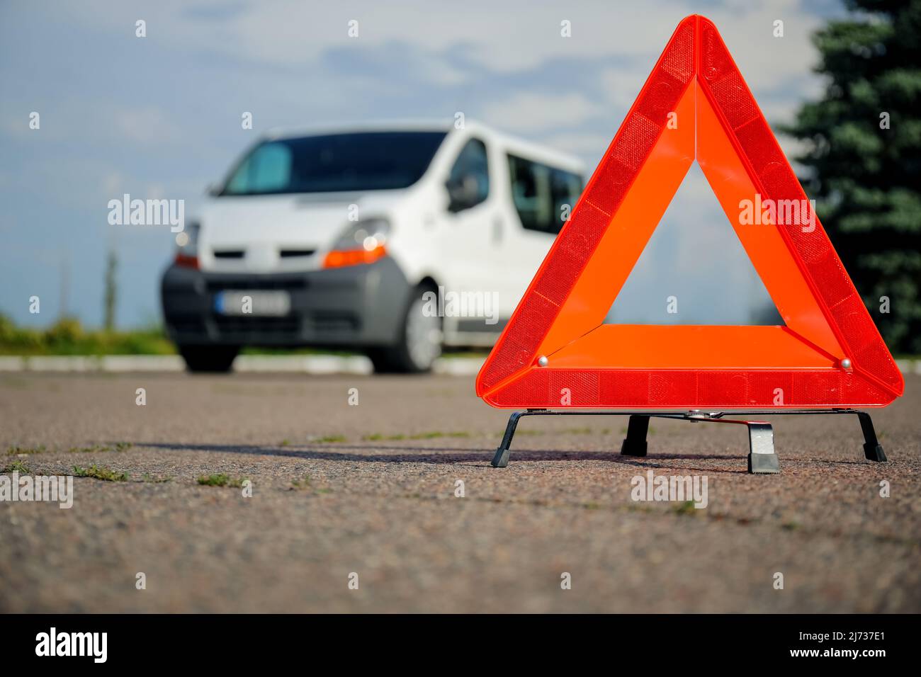Red emergency triangle stop sign and broken car on road Stock Photo - Alamy