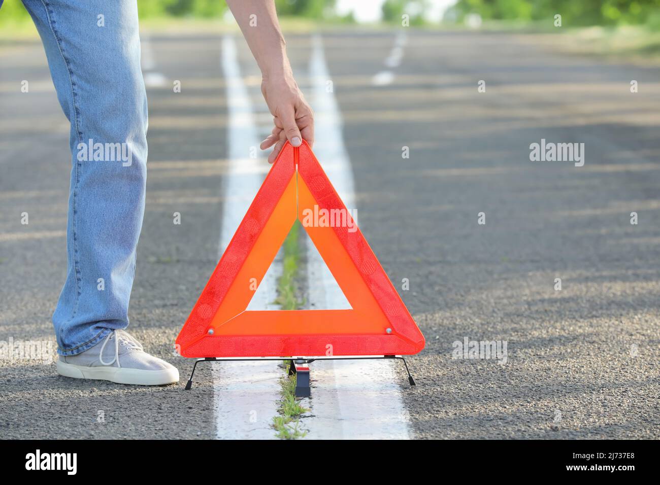 Man putting emergency stop sign on road Stock Photo - Alamy