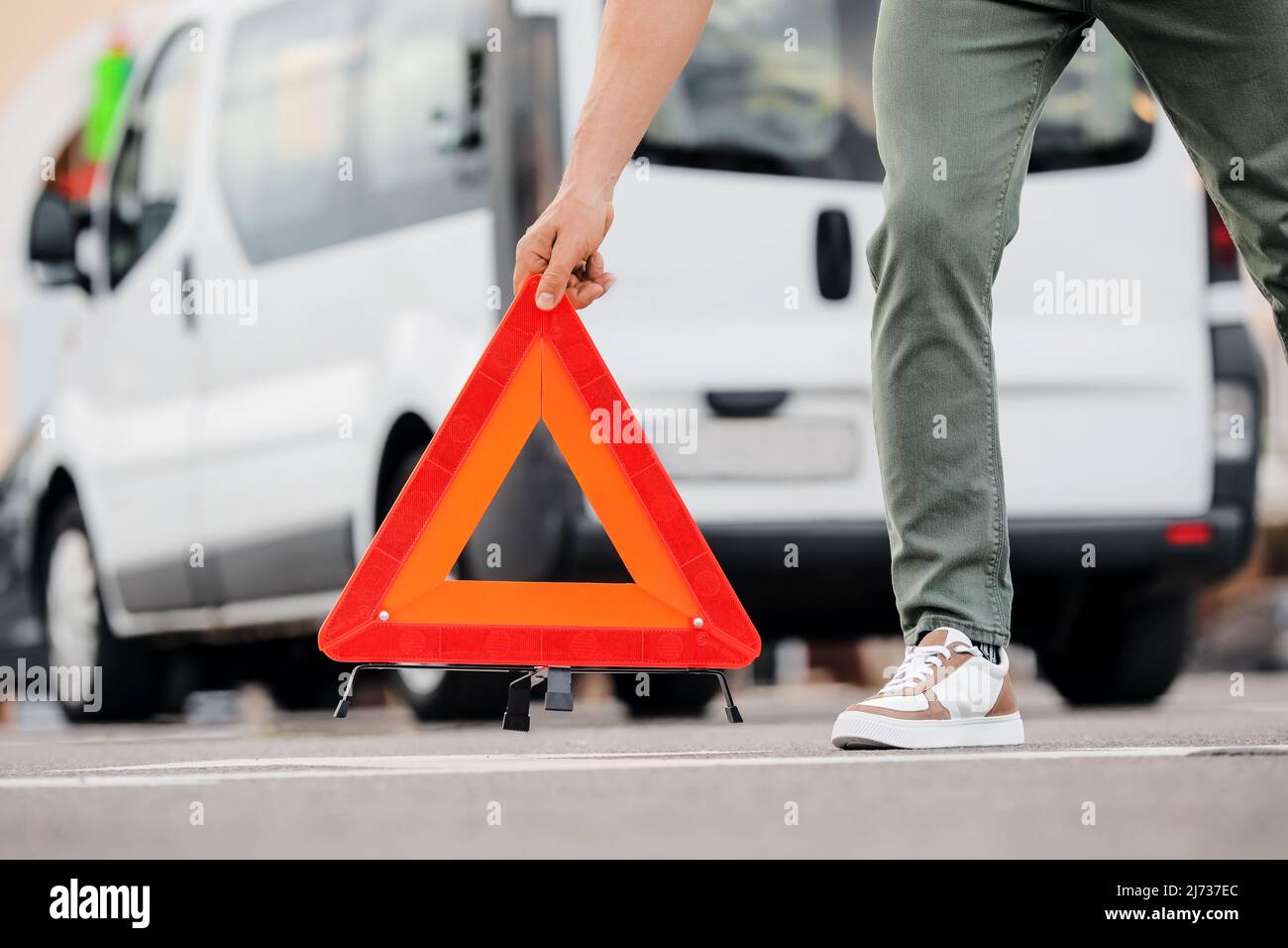 Man putting red emergency stop sign on road Stock Photo - Alamy