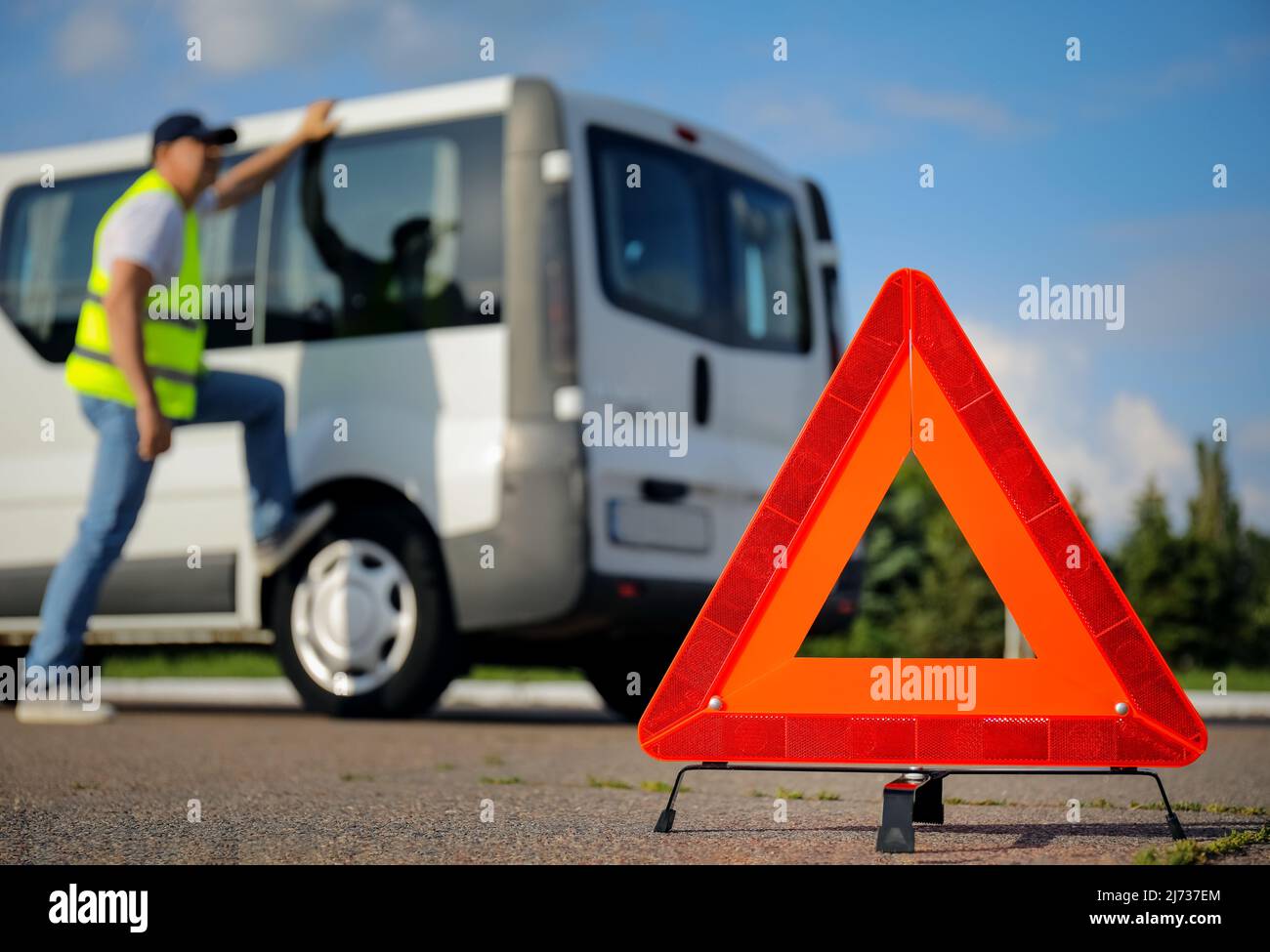Emergency triangle stop sign and man near broken car on road Stock ...