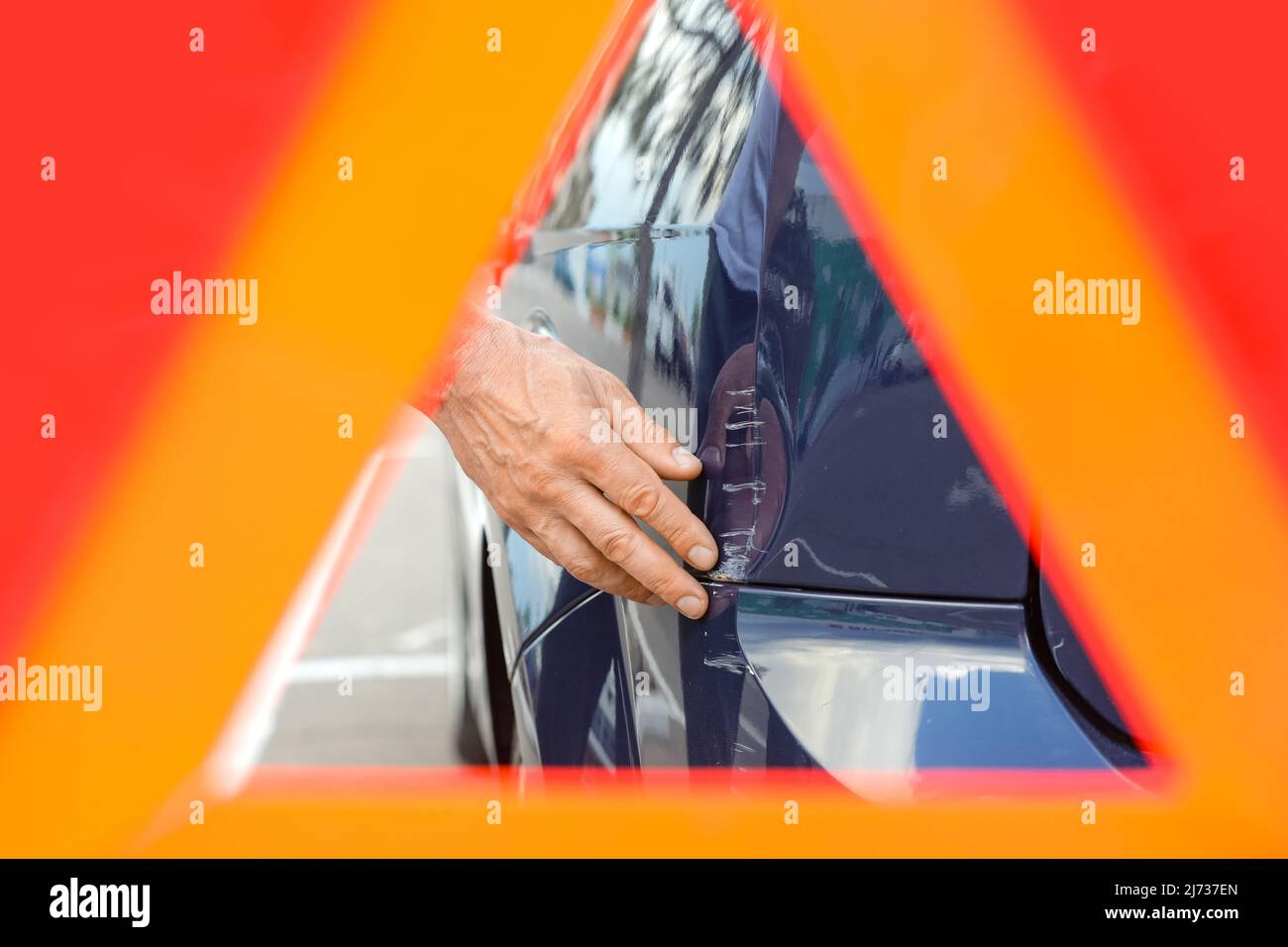 Male hand and broken car visible through emergency stop sign Stock ...