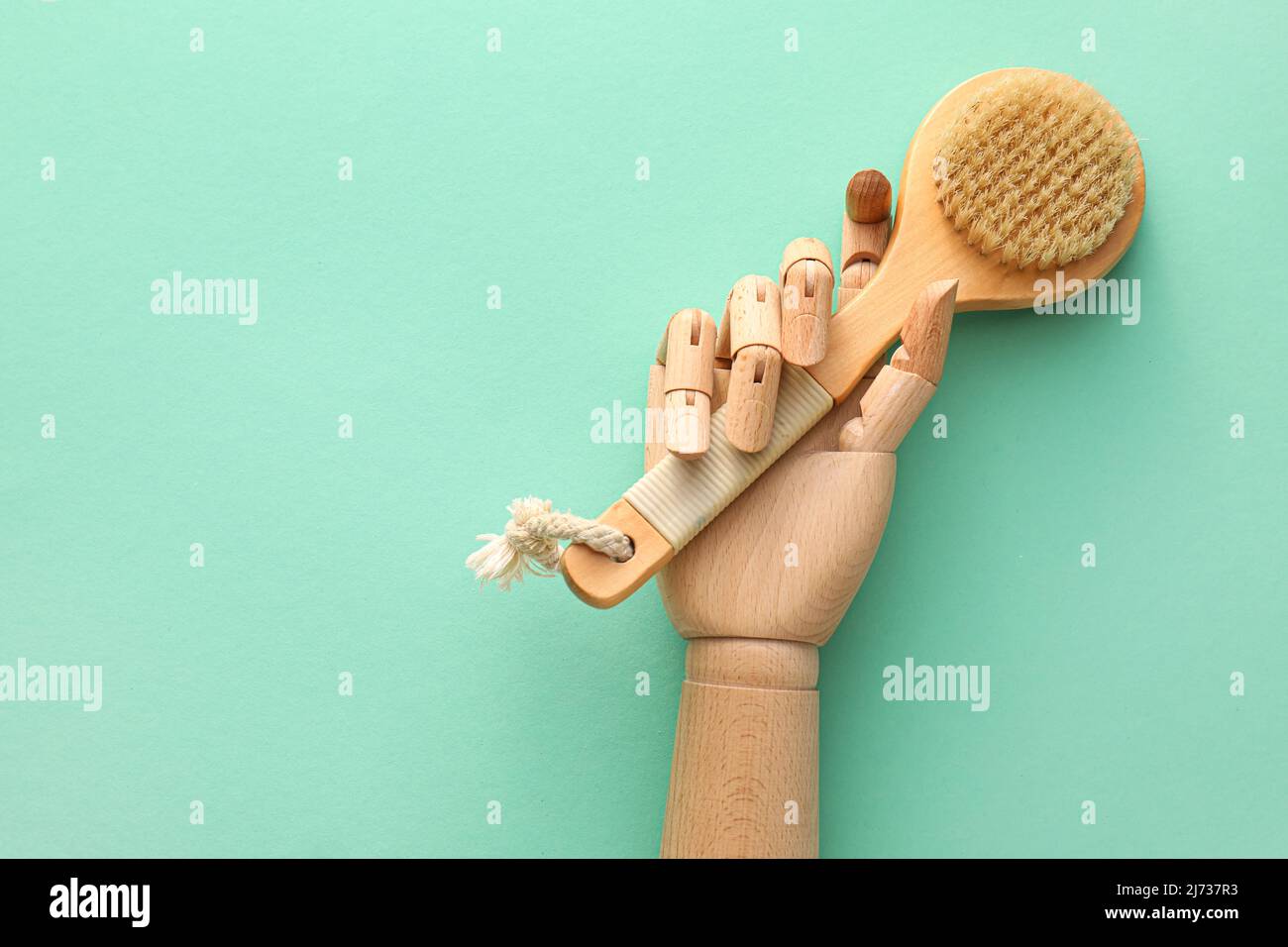 Wooden hand with massage brush on turquoise background Stock Photo - Alamy