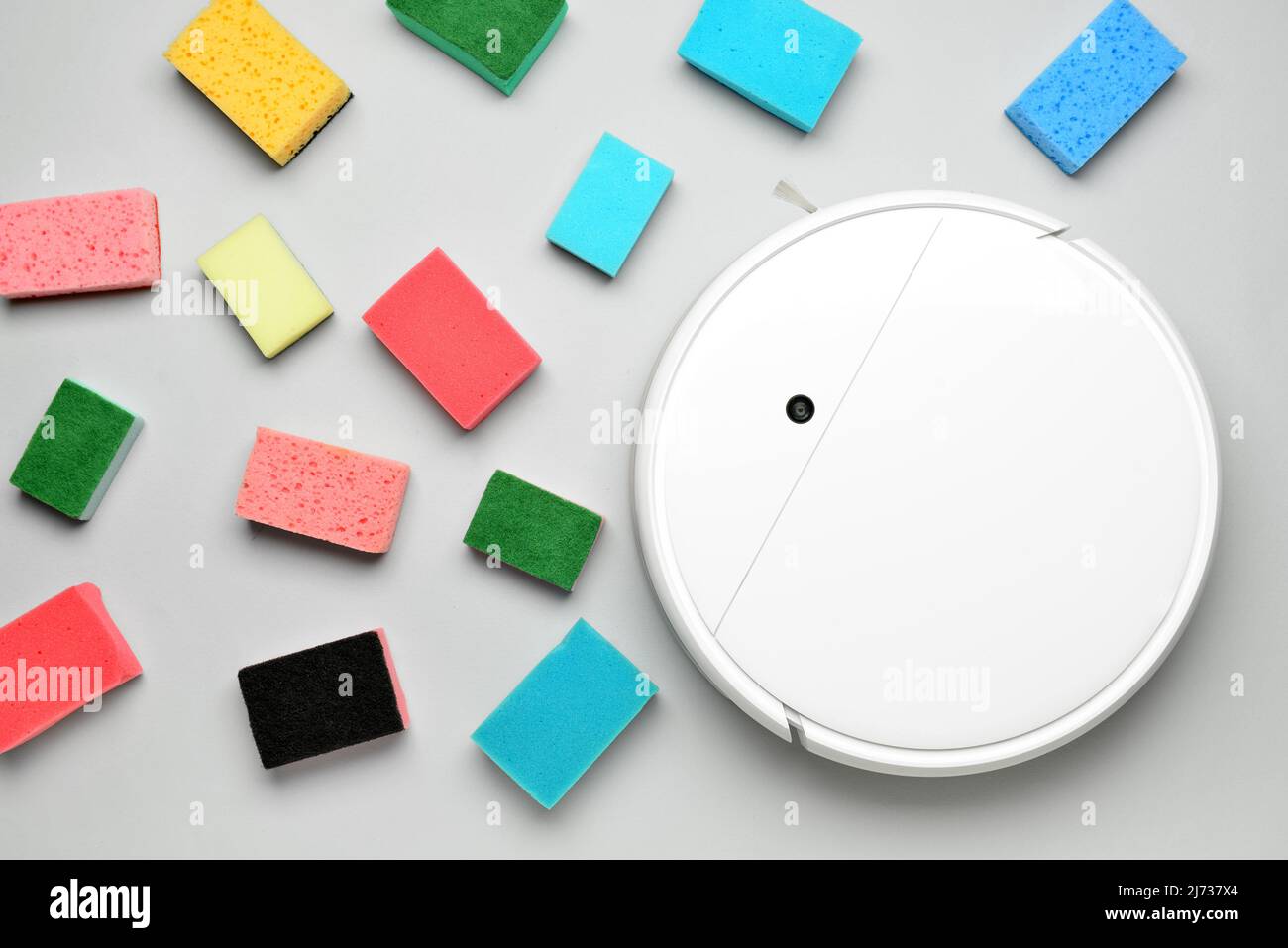 Robot vacuum cleaner and sponges on white background Stock Photo - Alamy