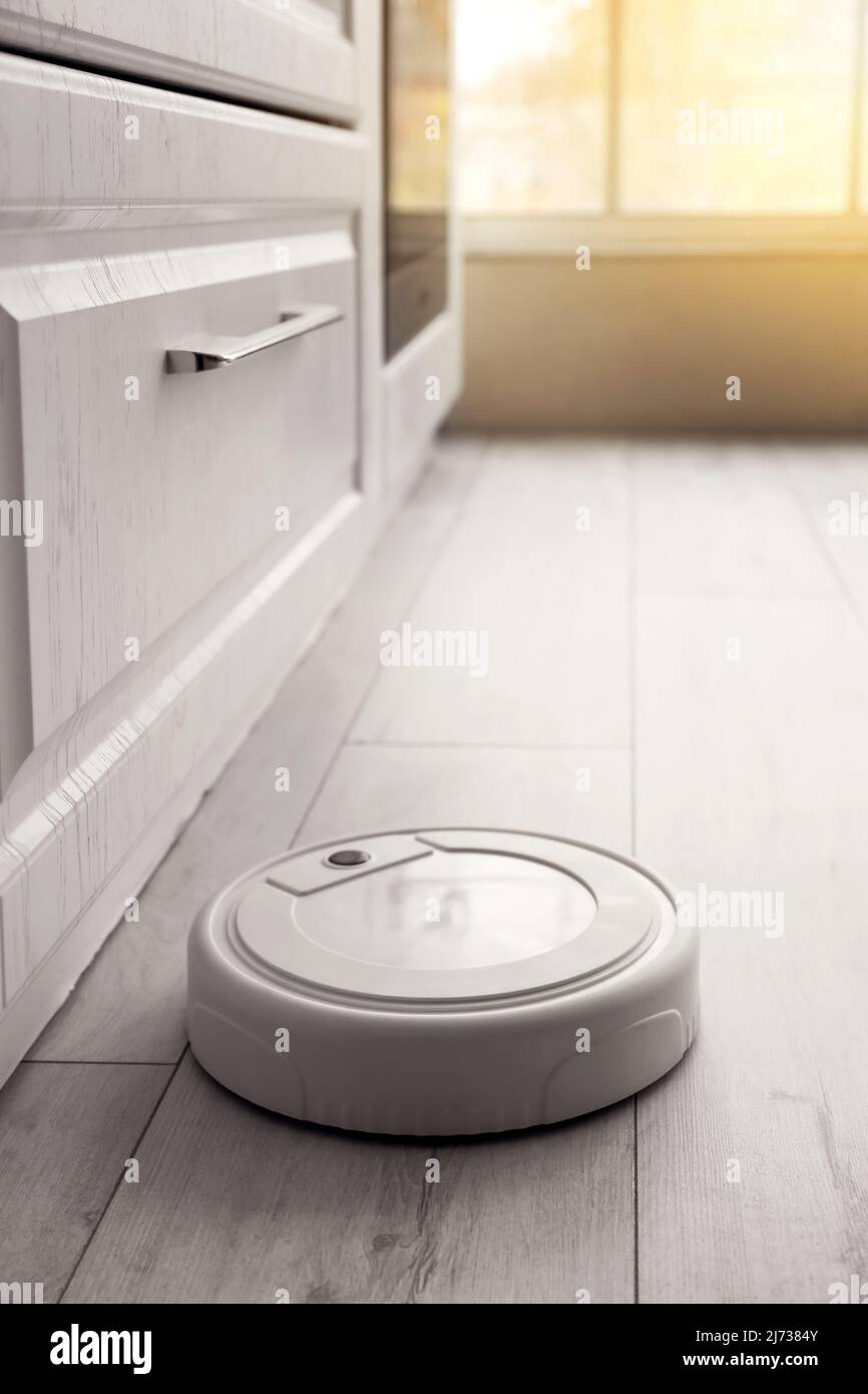 Modern robot vacuum cleaner near counter in kitchen Stock Photo - Alamy