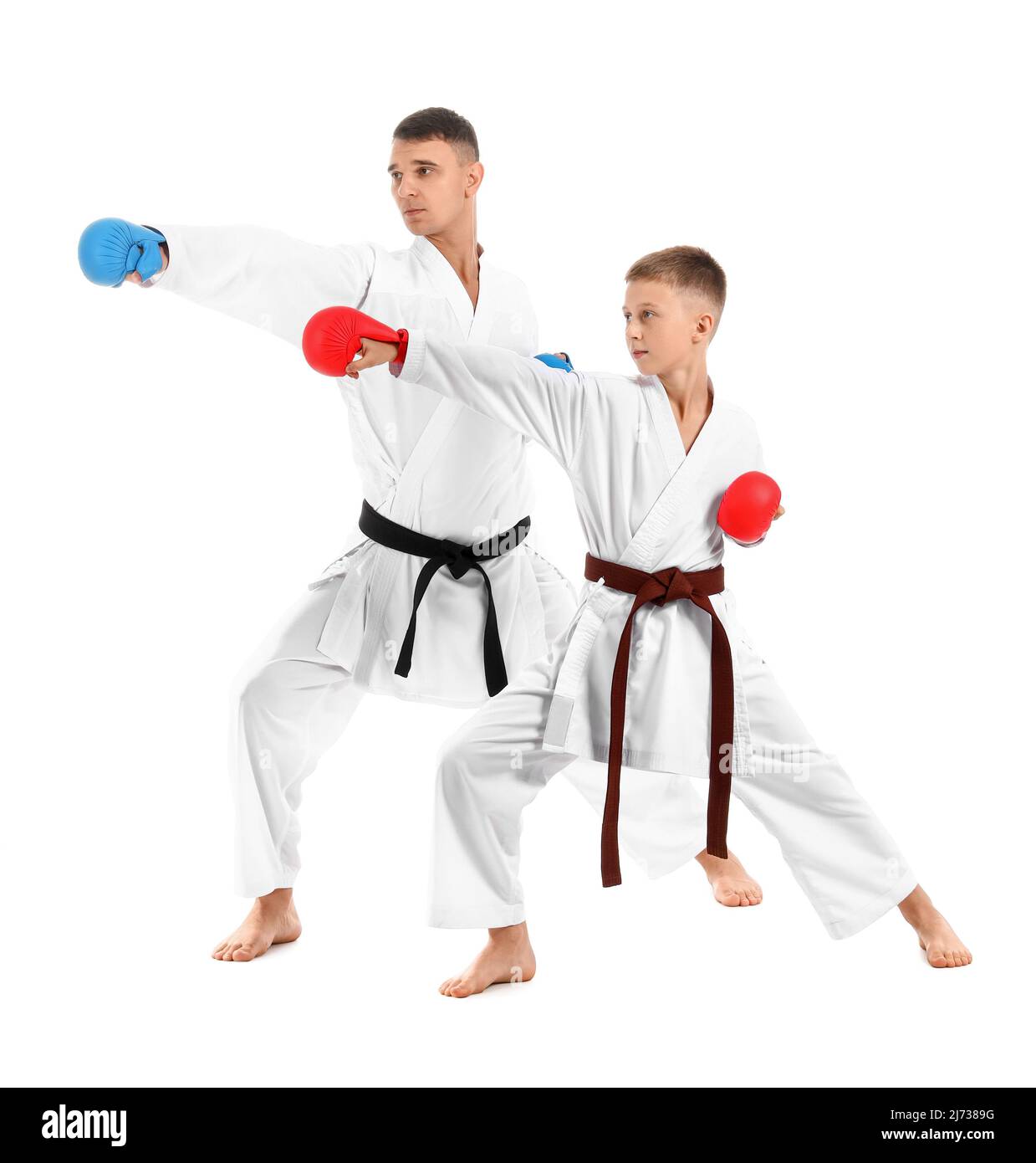 Boy practicing karate with instructor on white background Stock Photo ...