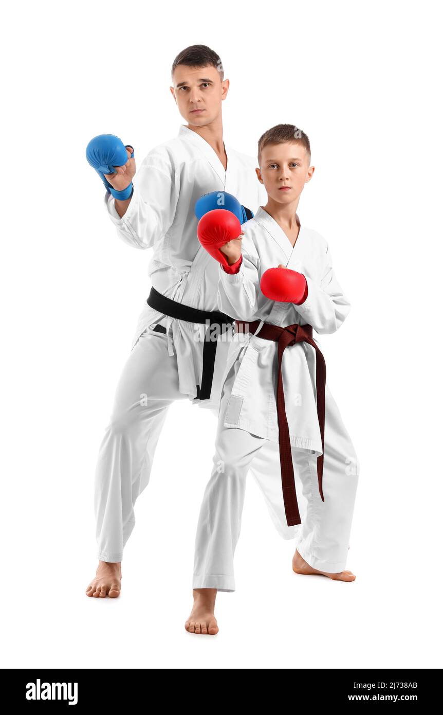 Boy practicing karate with instructor on white background Stock Photo ...