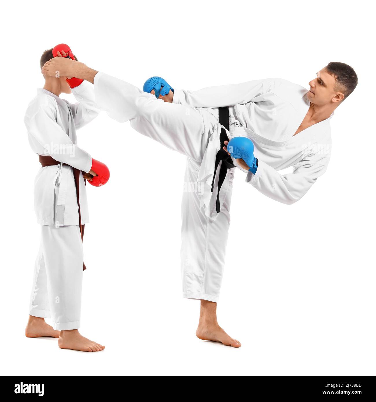 Boy practicing karate with instructor on white background Stock Photo ...