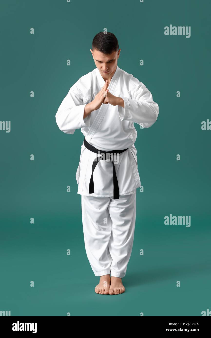 Man performing ritual bow before practicing karate on green background ...