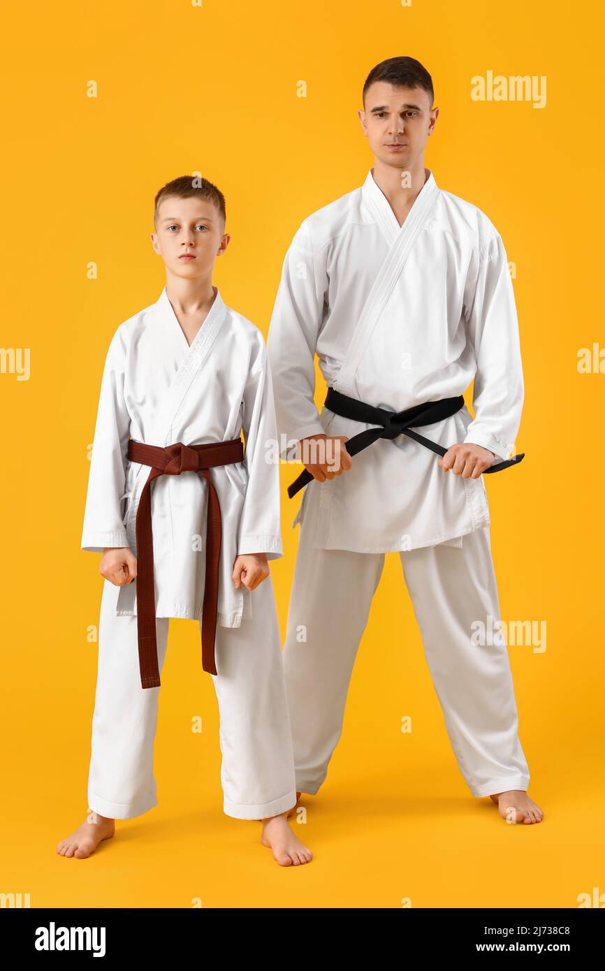 Boy and instructor in karategi on yellow background Stock Photo - Alamy
