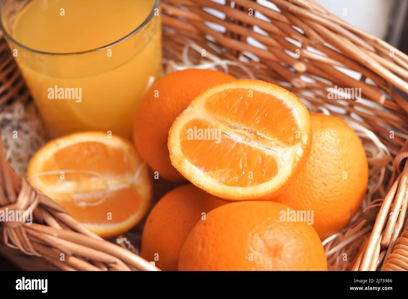 Glass of orange juice and fruits in basket in summer on the window sill ...