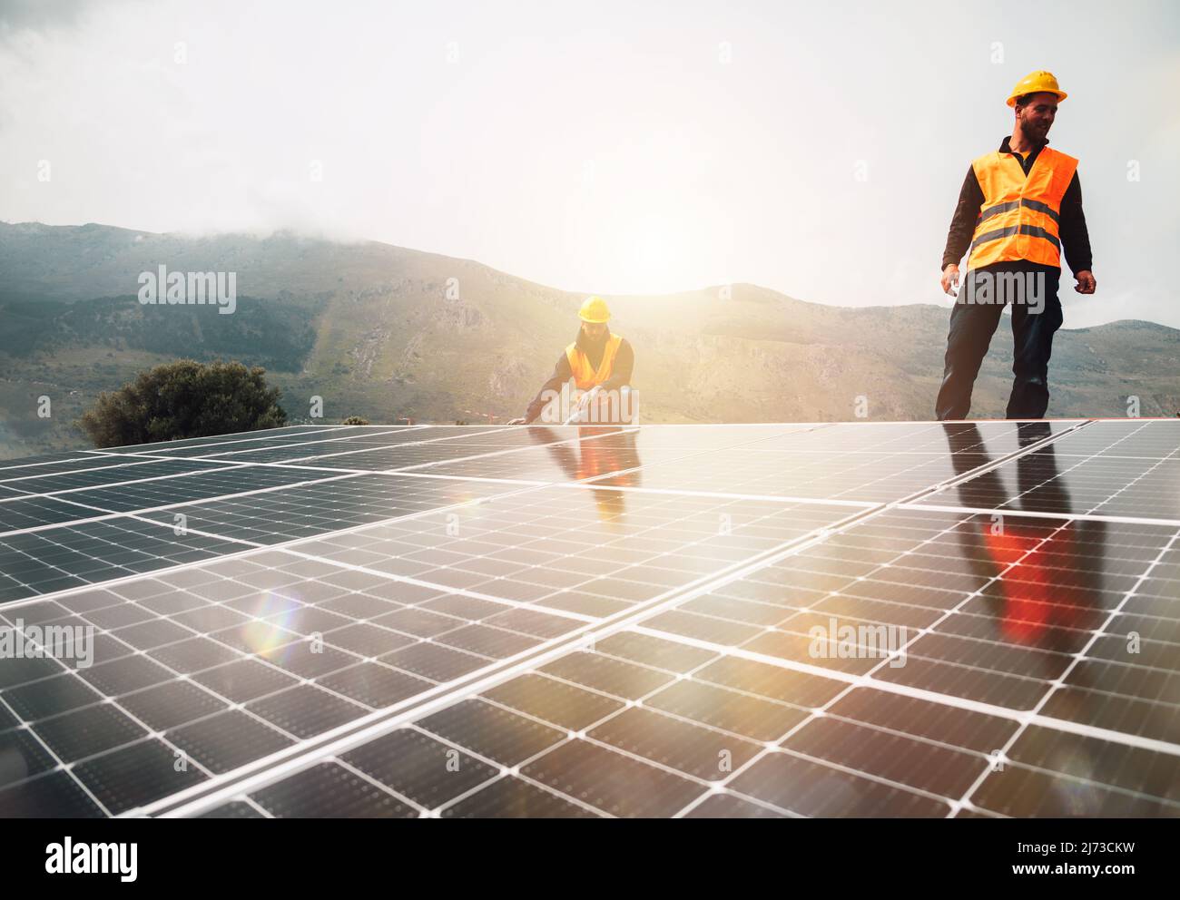 Workers assemble energy system with solar panel for electricity Stock ...