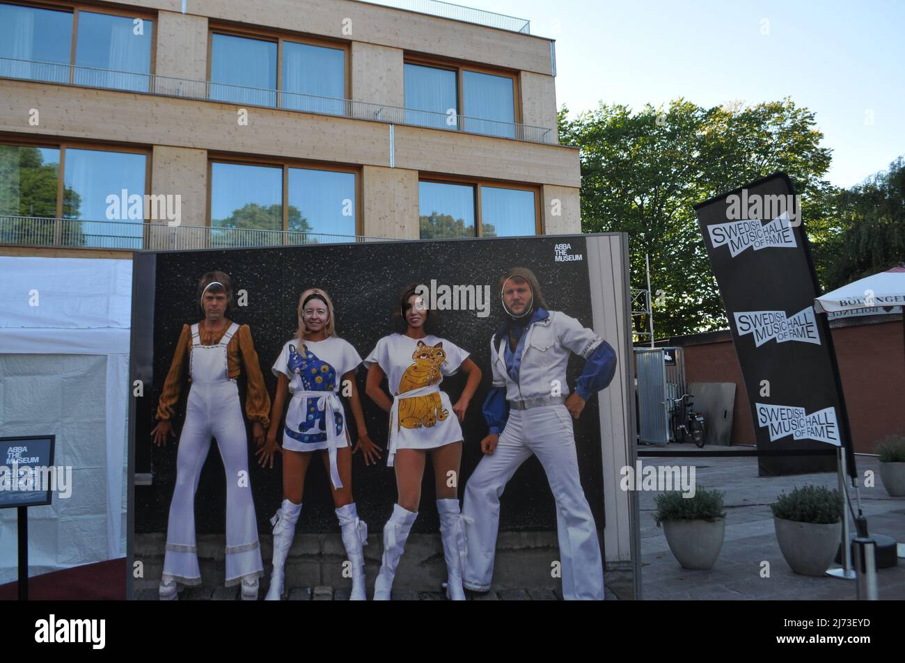 Tourists pose at a photo stand-in outside ABBA The Museum in Stockholm ...