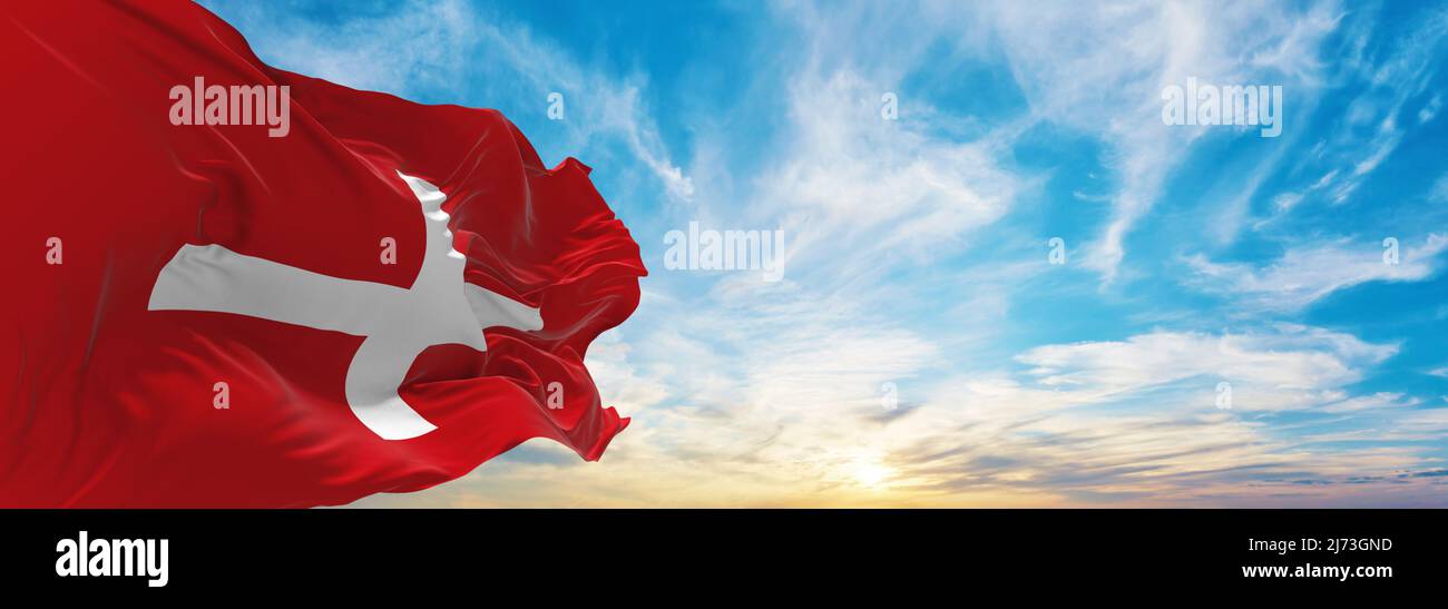 flag of the Republic of Noli, Italy at cloudy sky background on sunset ...