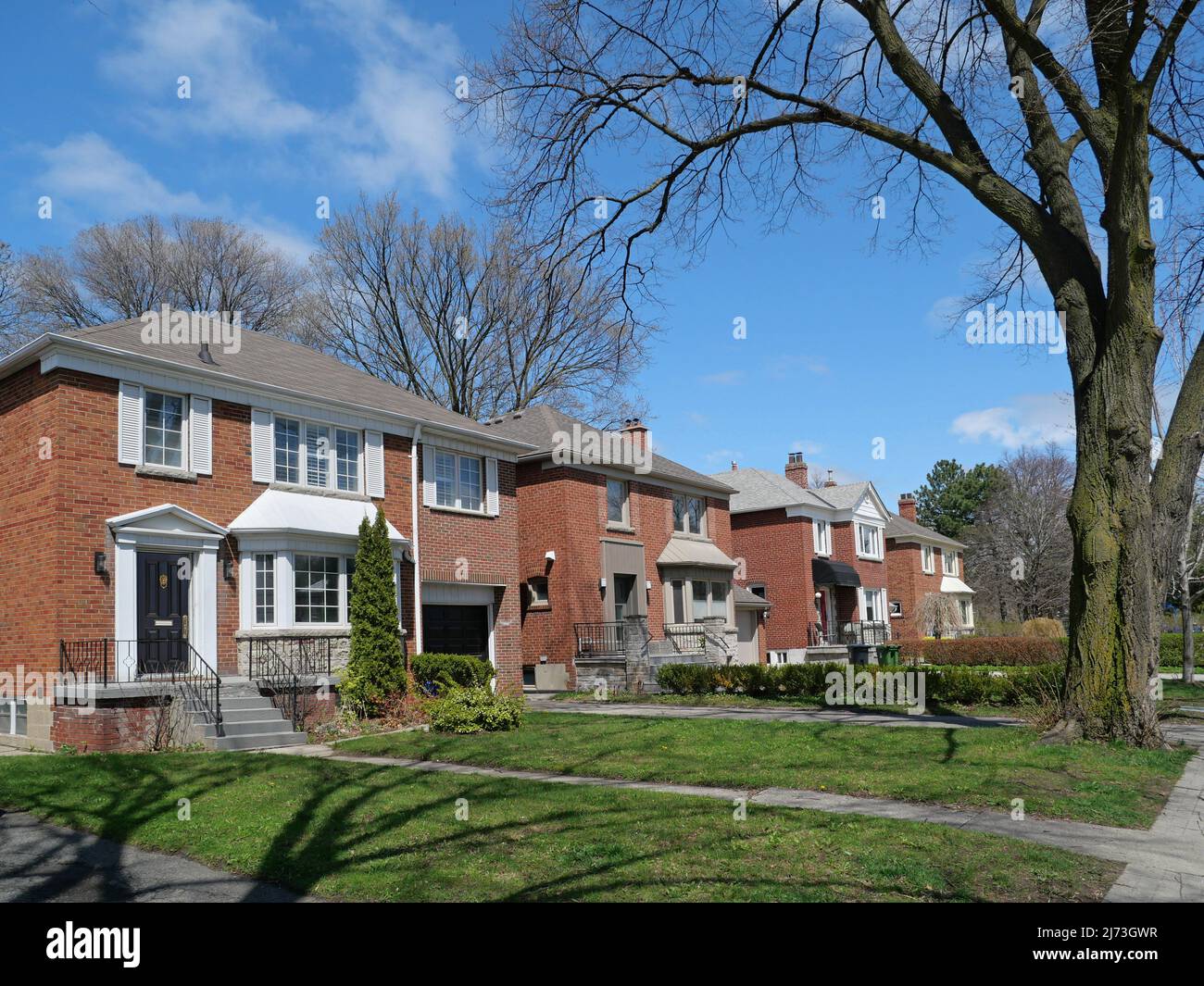 Suburban residential street with traditional two story brick houses ...