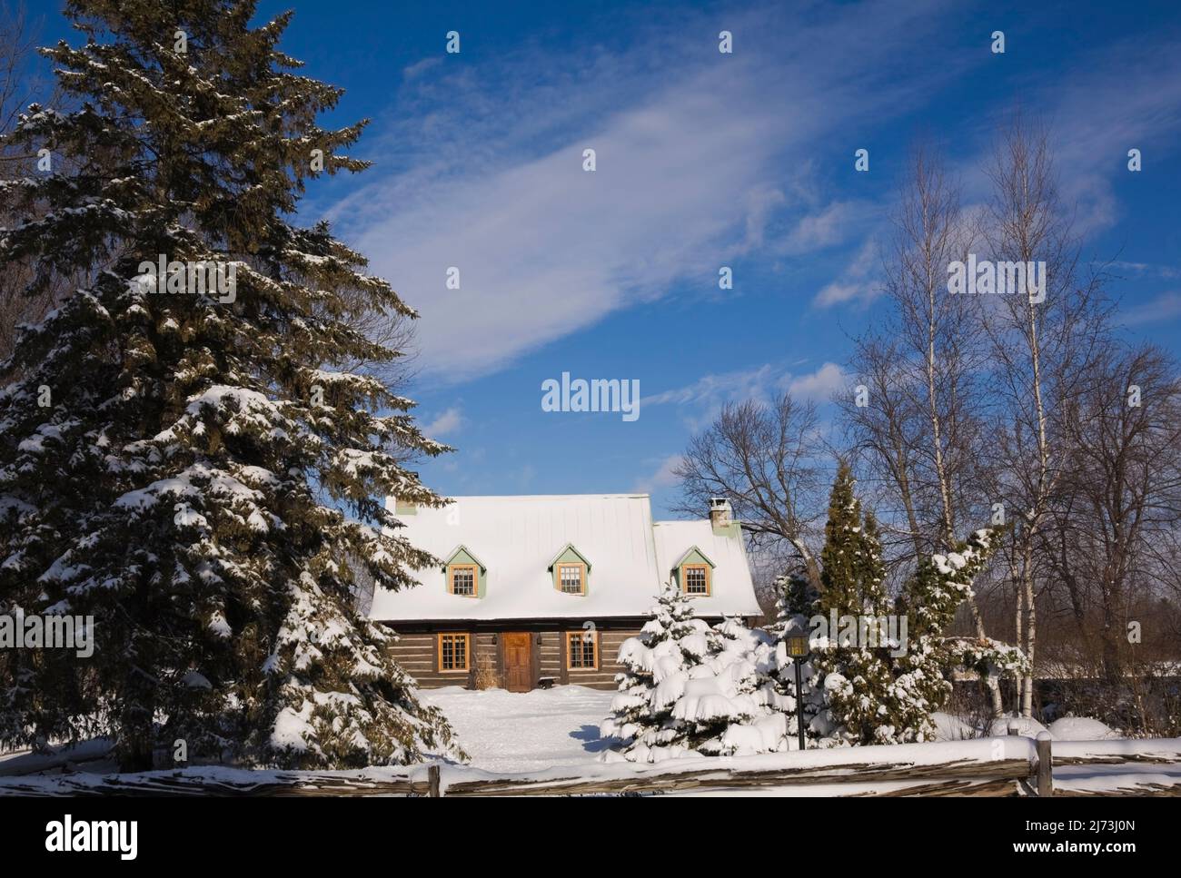 Old 1800s Canadiana style log home protected by rustic wooden fence in ...