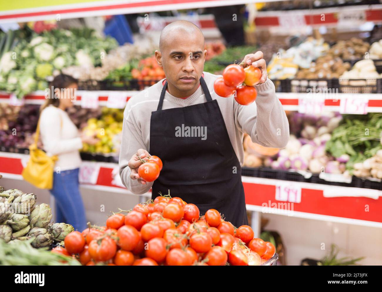 Portrait of latino-american worker in supermarket with vegetable Stock ...