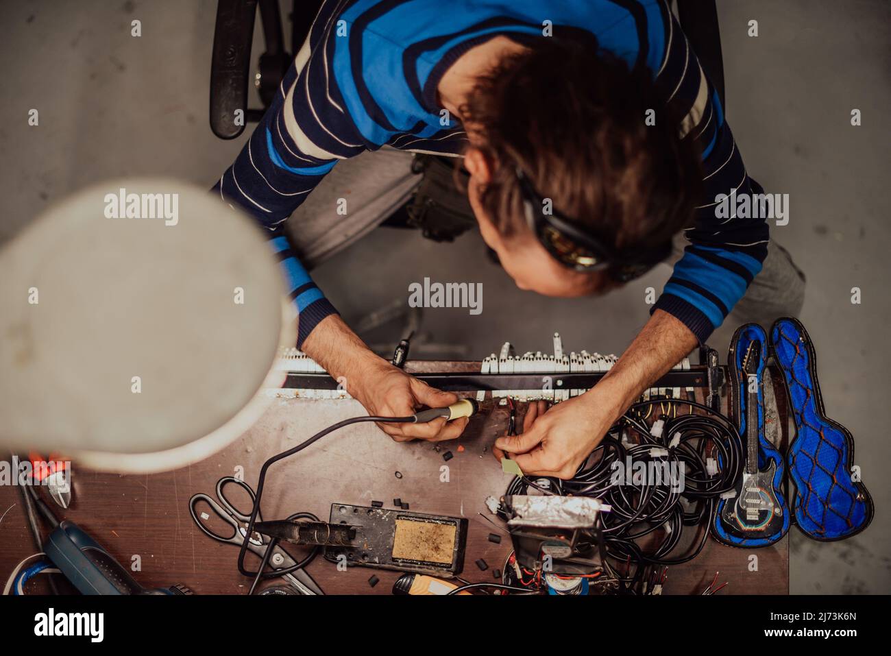 Industrial worker man soldering cables of manufacturing equipment in a ...