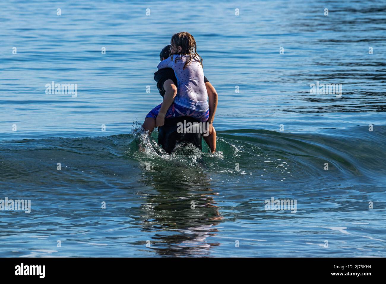 Playing in the waves Stock Photo - Alamy