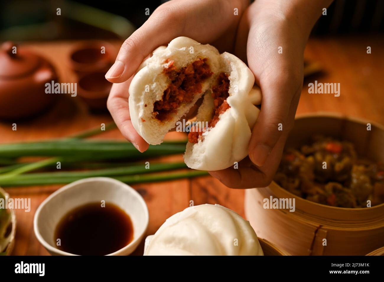 Chinese dim sum cuisine concept, Female hands holding a steamed pork ...