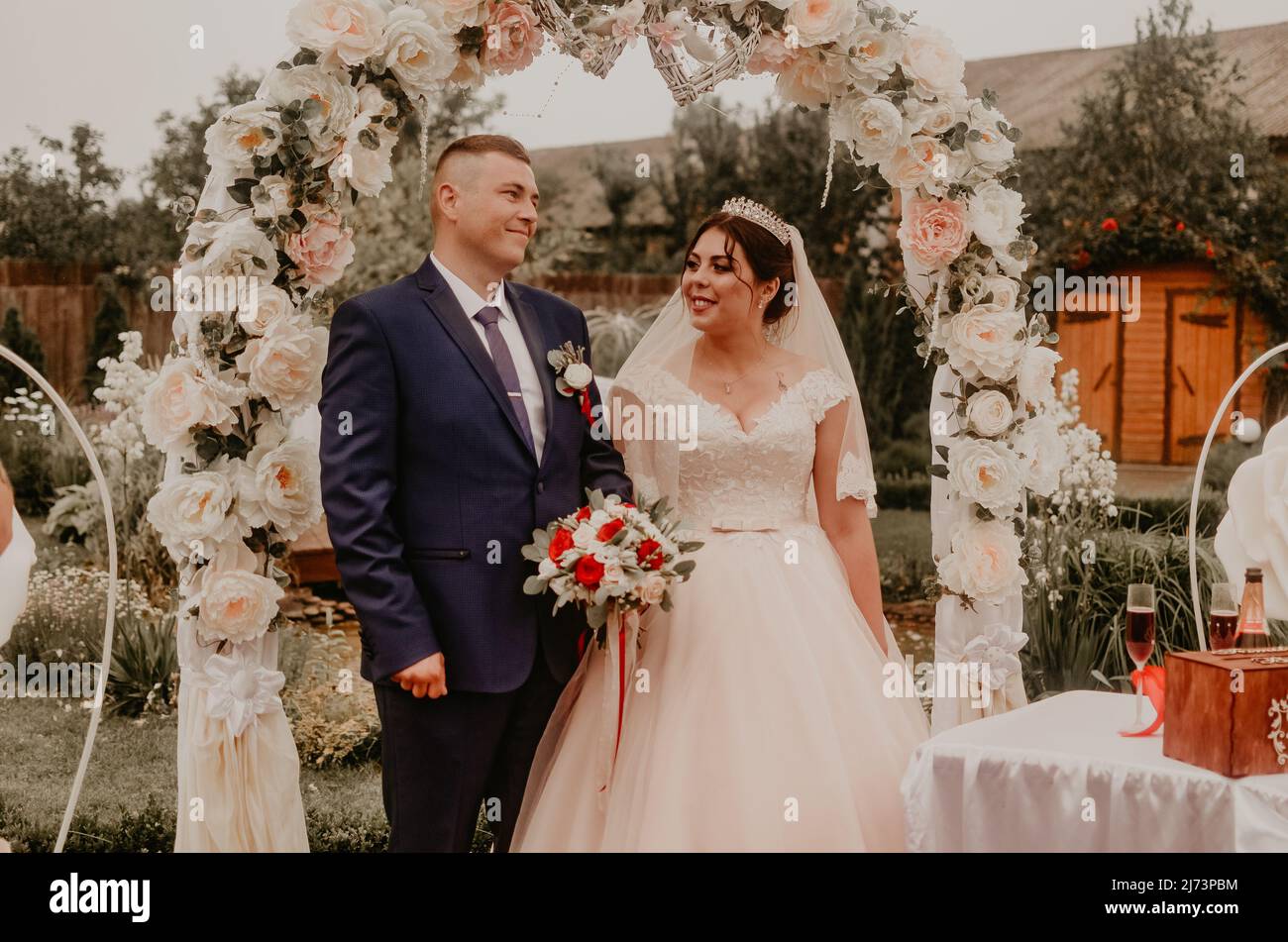Bride and groom in a wedding dress and a long veil at a wedding ...
