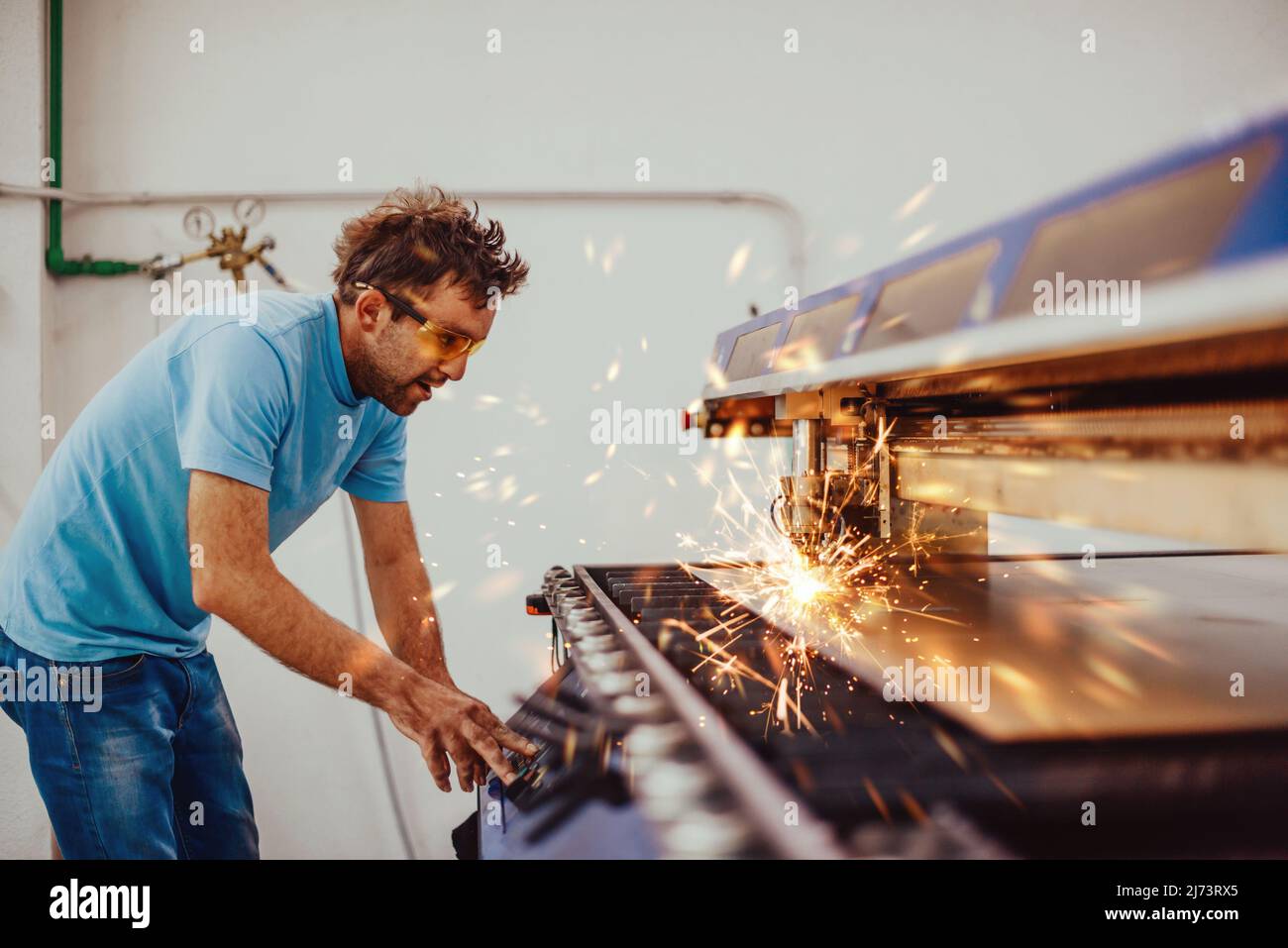 Within heavy industry. A man works in a modern factory on a CNC machine ...
