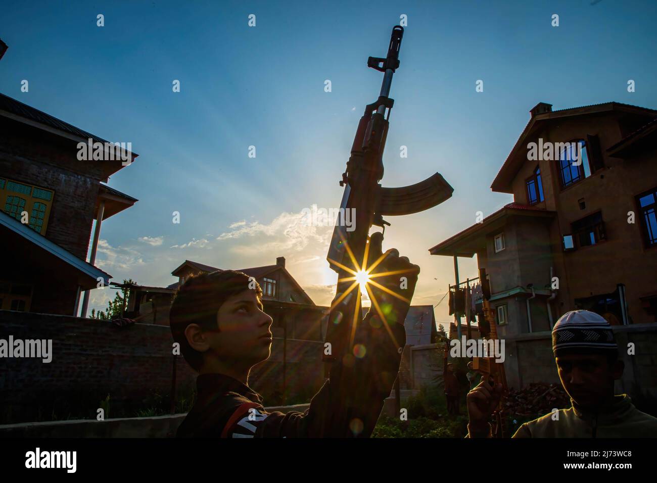 Silhouette of Kashmiri Muslim children playing guns. As part of Eid-ul ...