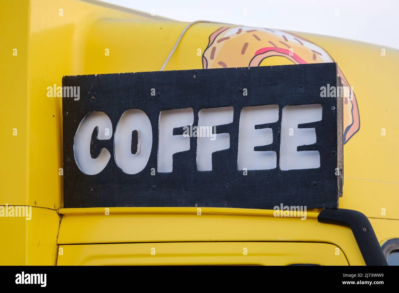 Coffee sign on yellow van Stock Photo - Alamy