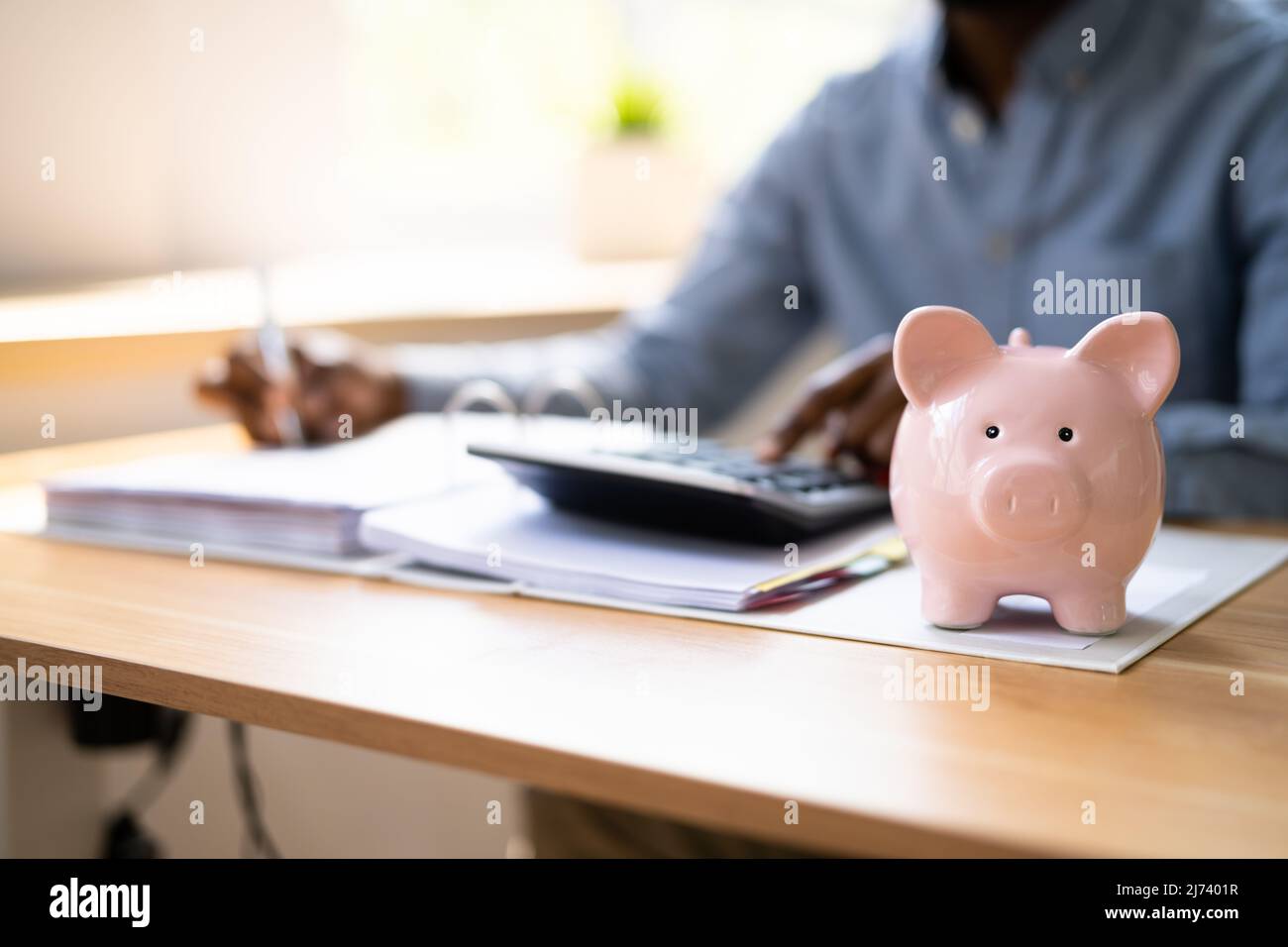 African Accounting Tax Advisor Using Calculator And Piggy Bank Stock ...