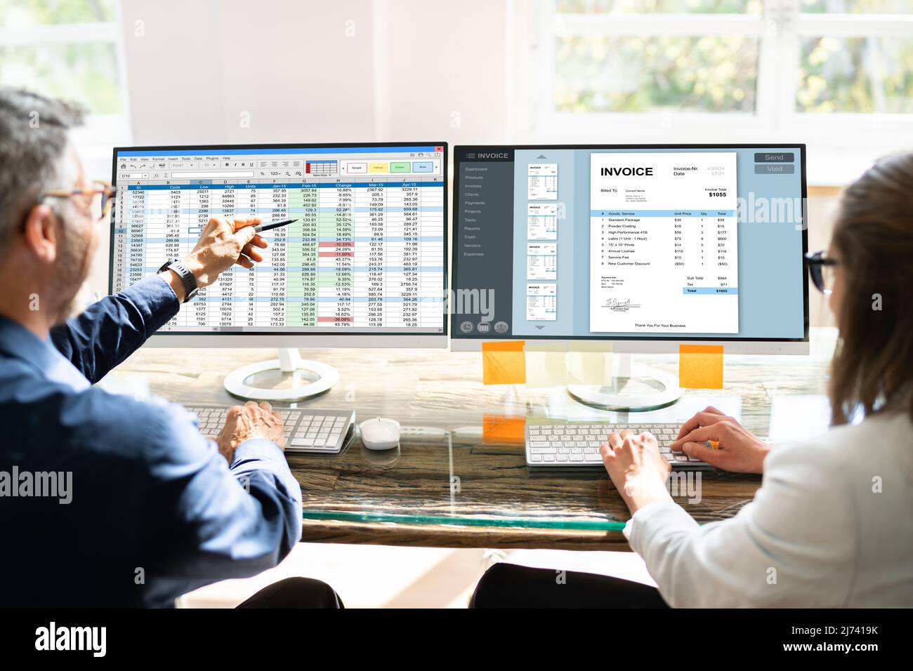 Accountants Looking At Invoice Spreadsheet On Computer Monitor Stock ...