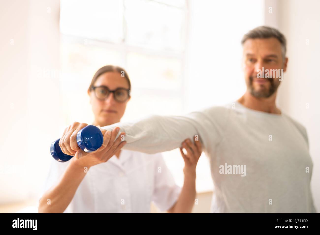 Physical Rehabilitation Therapist Helping Man. Physiotherapy ...