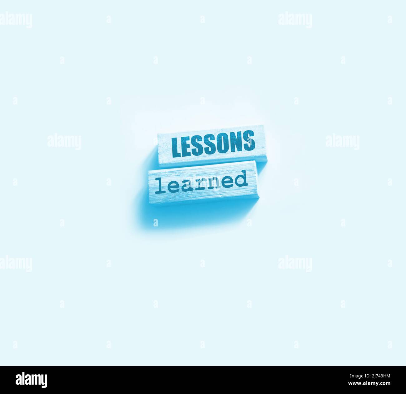 Wooden blocks wtih text Lessons learned on pink background. Business ...