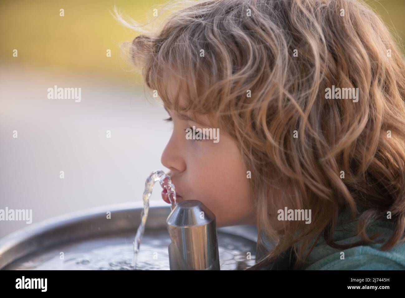 Child drinking water from a water fountain in park outdoor Stock Photo ...