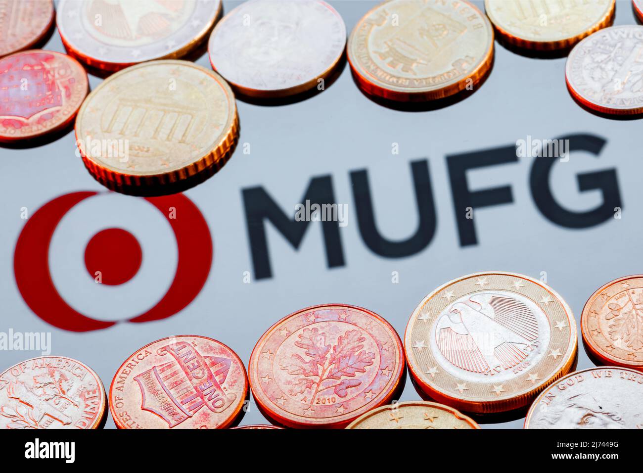 Variety of metal coins on background of Mitsubishi UFJ Financial Group logo Stock Photo - Alamy