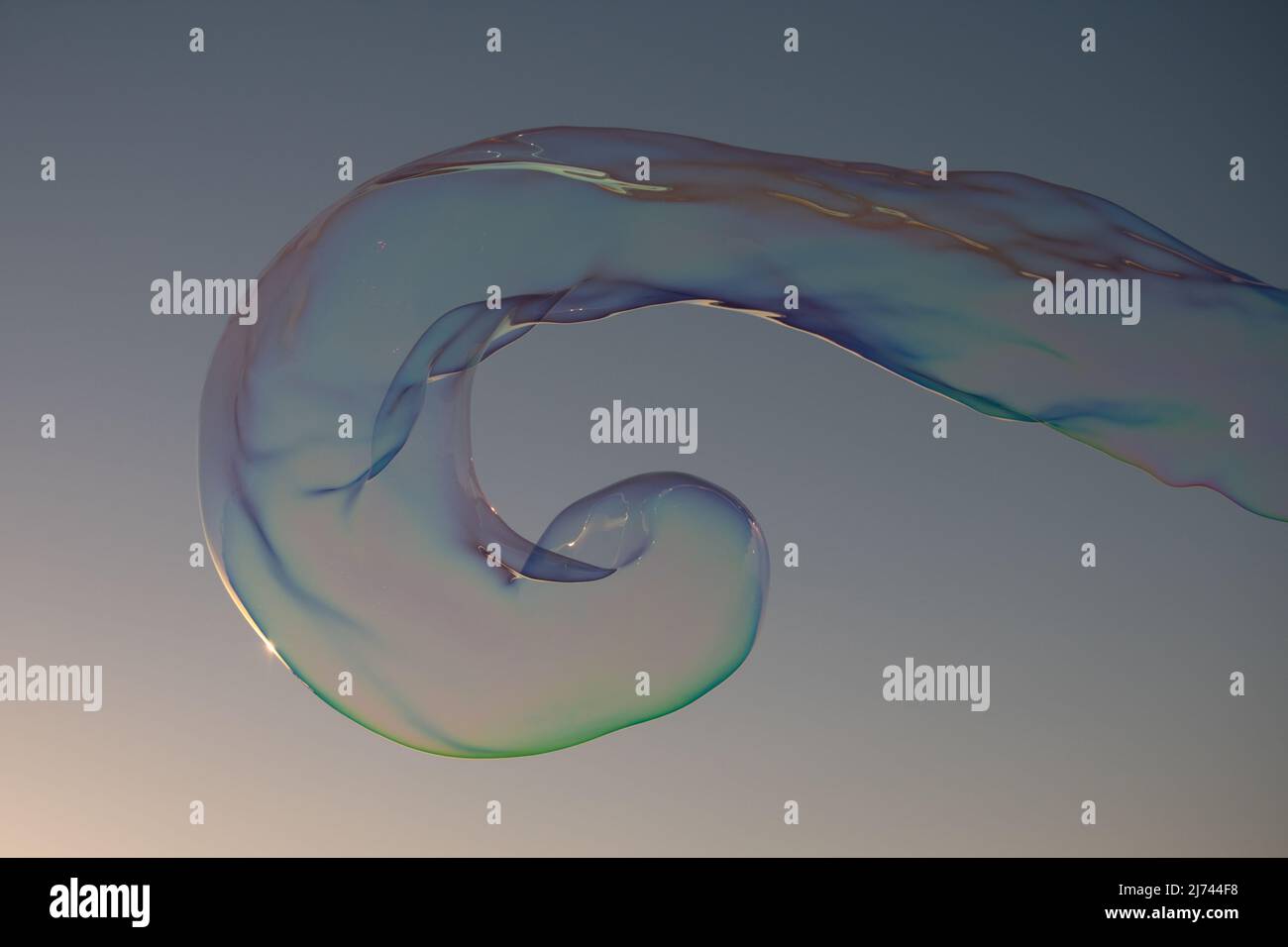 Giant colorful bubble. Big soap bubble on blue sky. Making huge rope ...