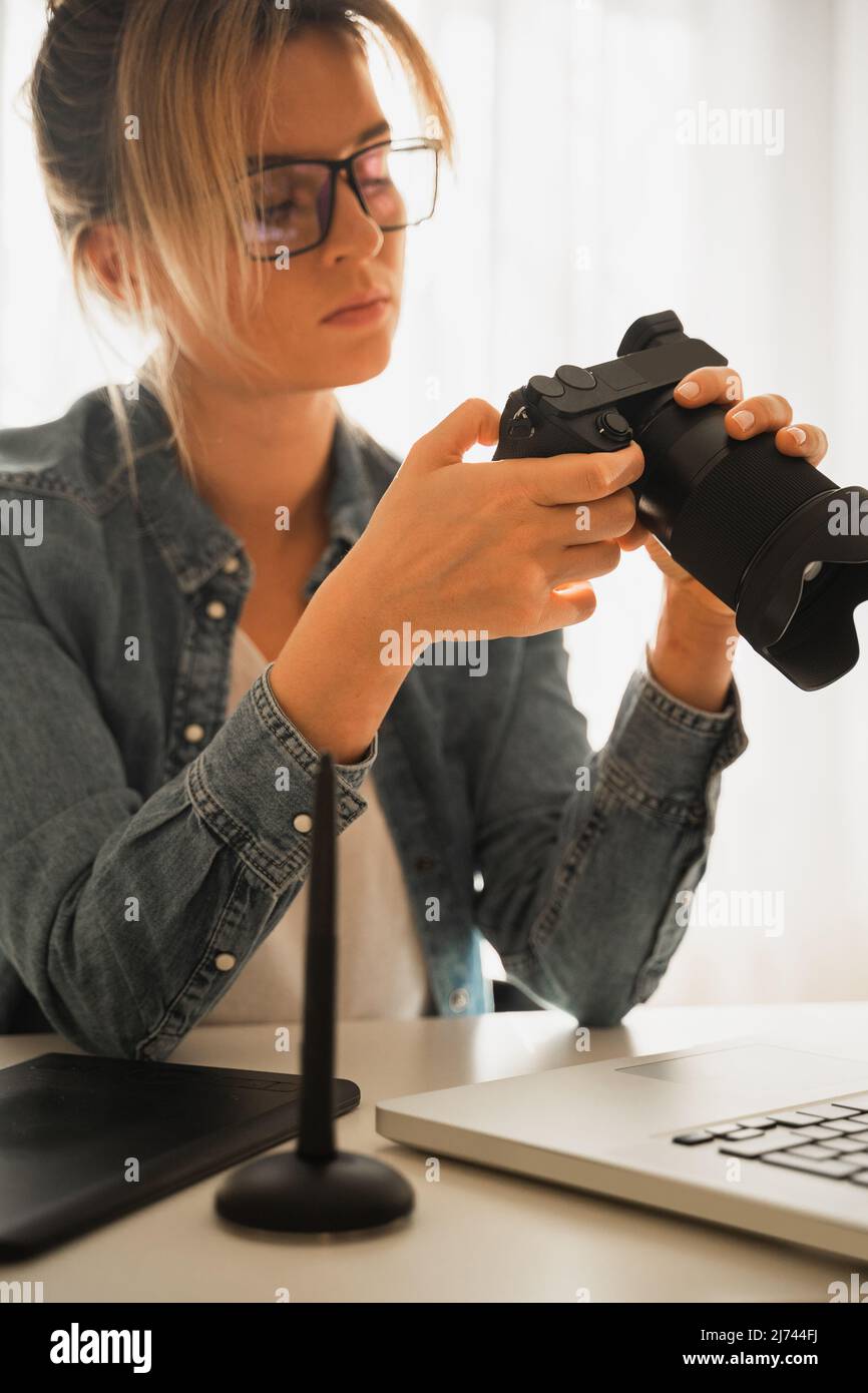 Woman photographer with a mirrorless camera at the workplace Stock ...