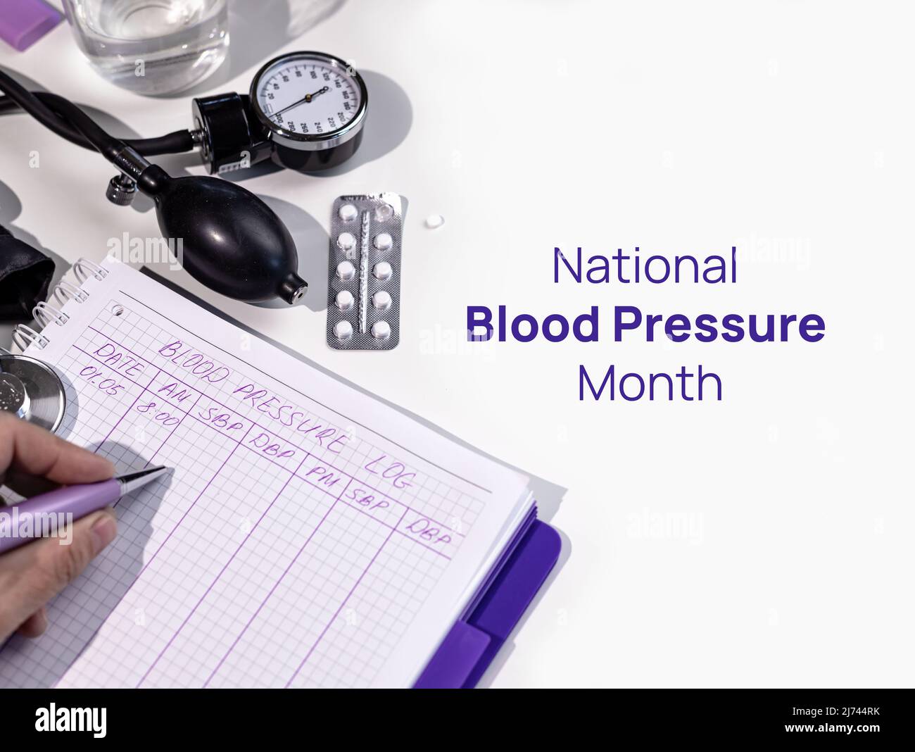 Blood pressure log with pen and Blood pressure monitor on white table ...