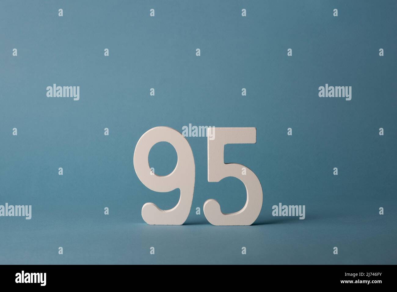 White wooden number ninety-five 95 on blue background Stock Photo - Alamy