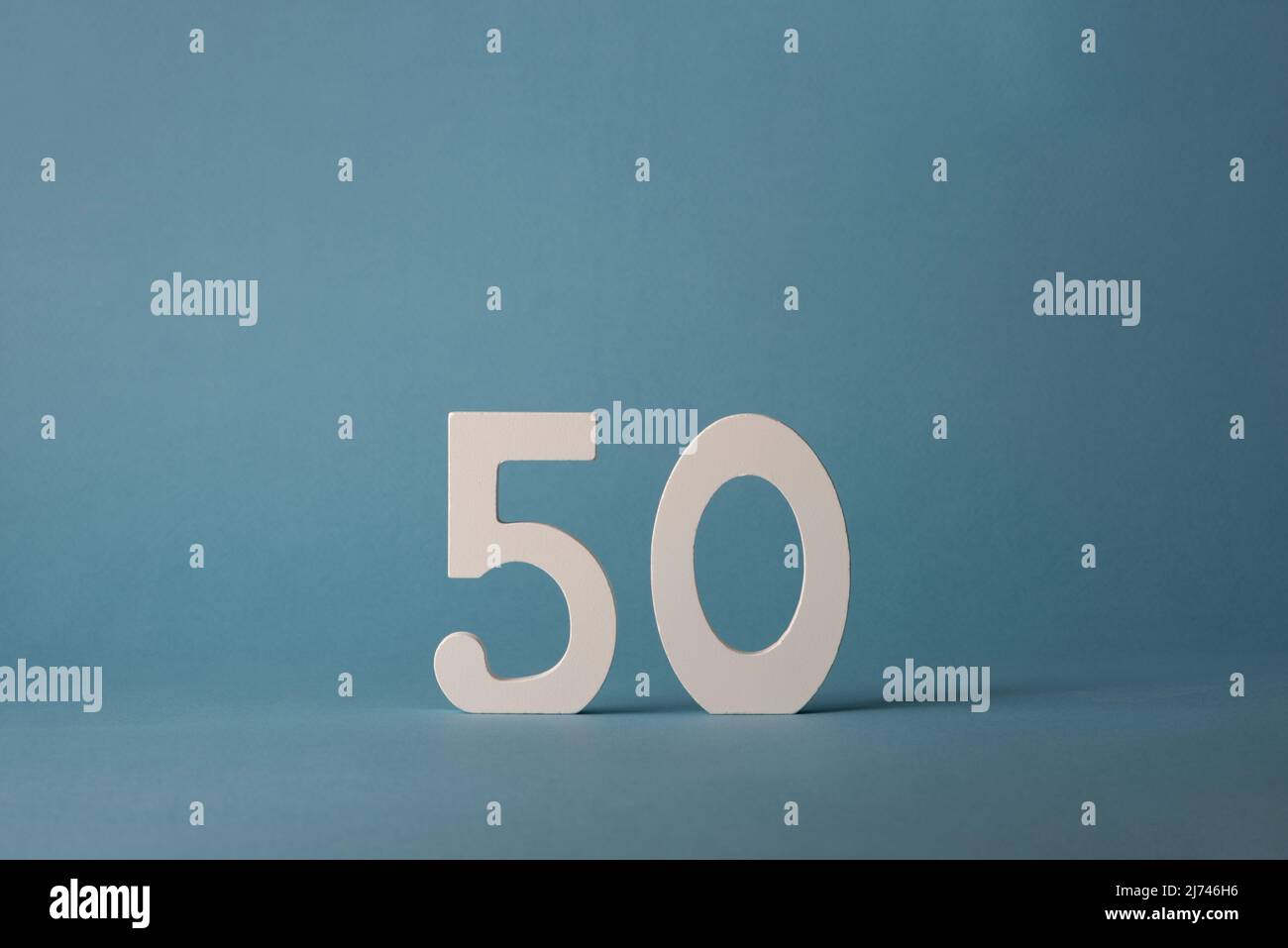 White wooden number fifty 50 on blue background Stock Photo - Alamy