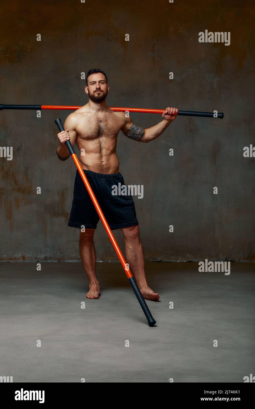 athlete men with stick training karate using sports tool in studio on ...
