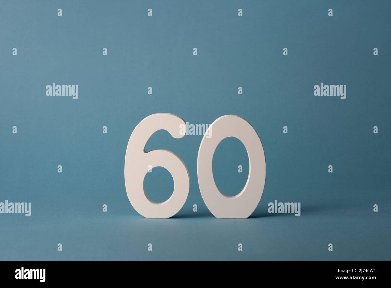 White wooden number sixty 60 on blue background Stock Photo - Alamy