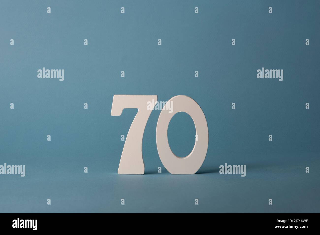 White wooden number seventy 70 on blue background Stock Photo - Alamy