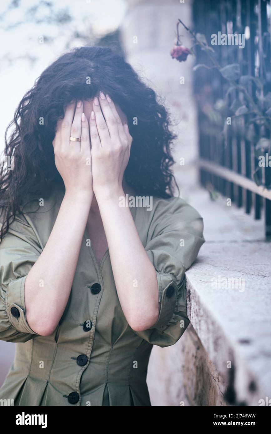 Woman hiding face with hands outdoors Stock Photo - Alamy