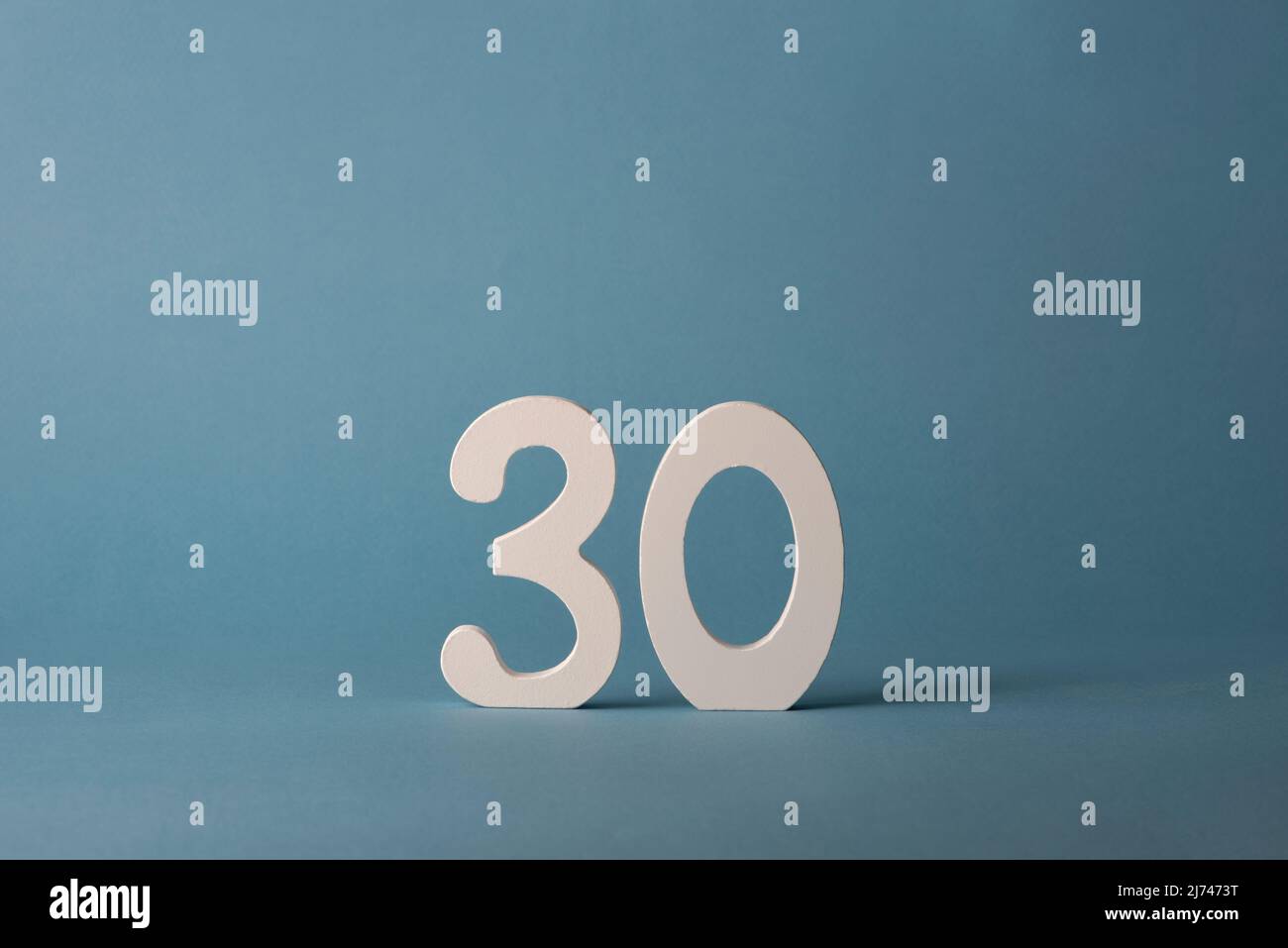 White wooden number thirty 30 on blue background Stock Photo - Alamy