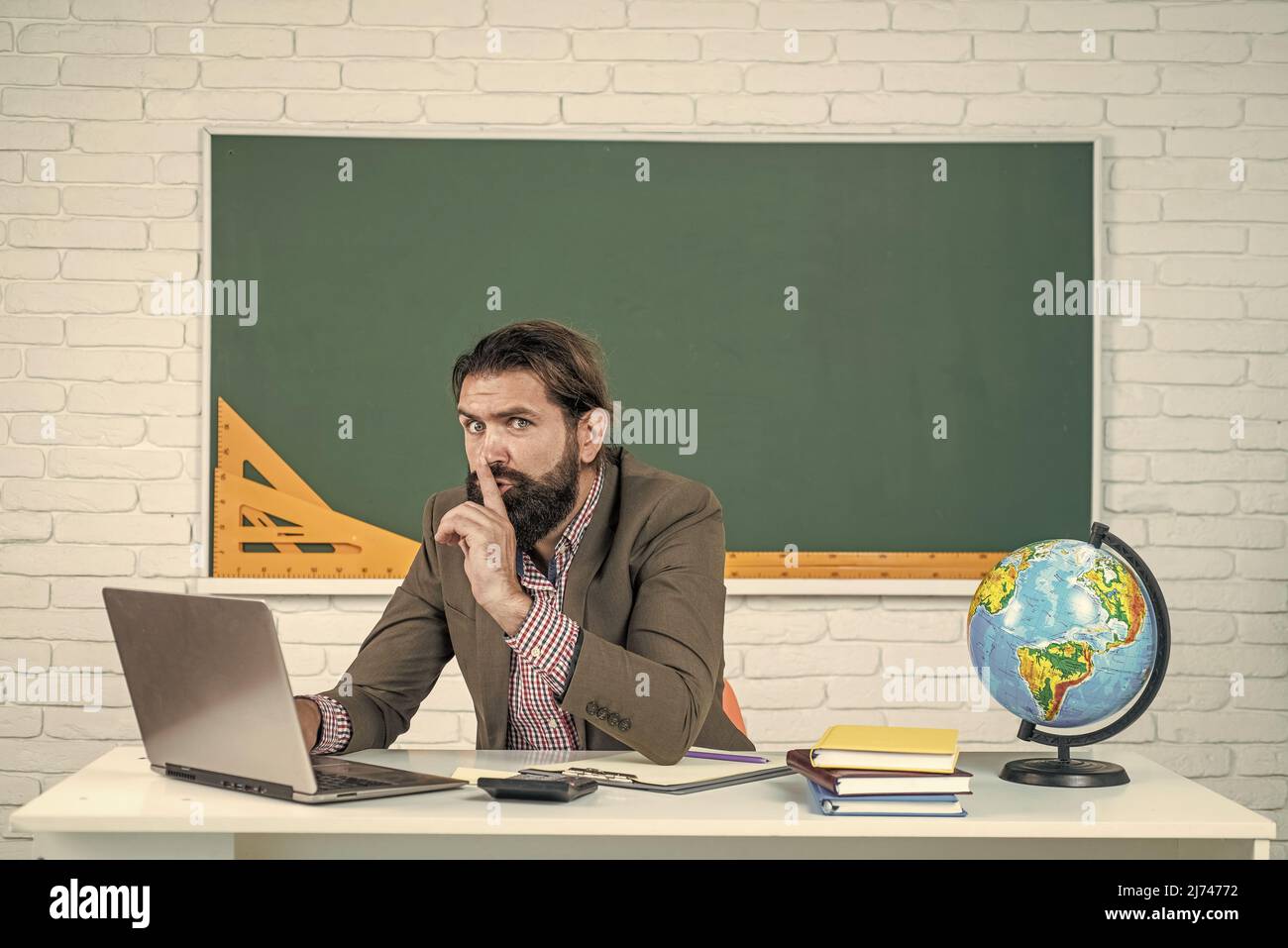 brutal bearded man work in classroom on computer. secret exam answers ...