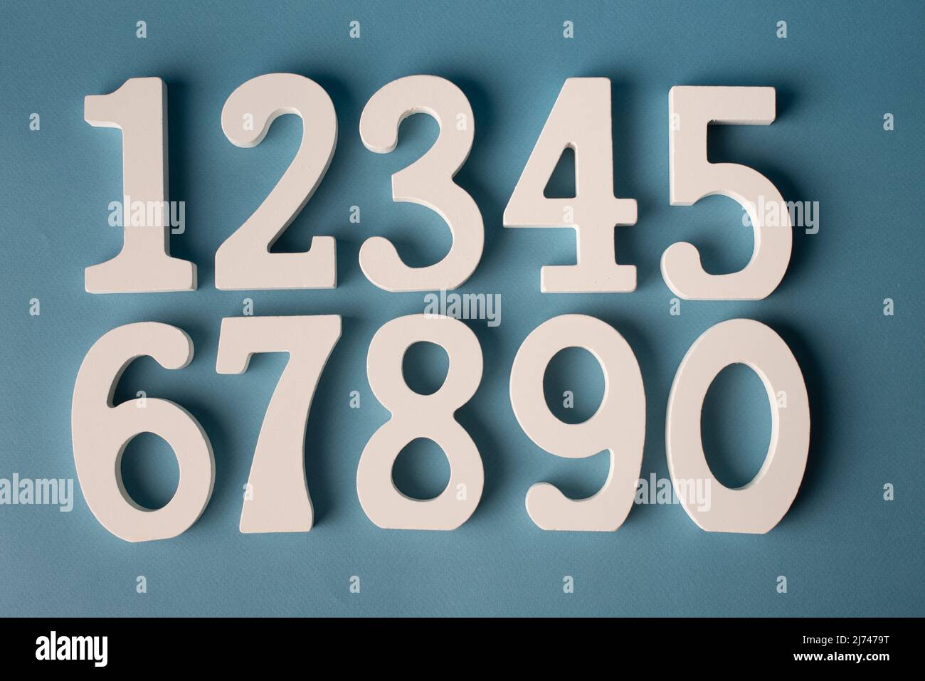 Set of white wooden numbers on blue background Stock Photo - Alamy