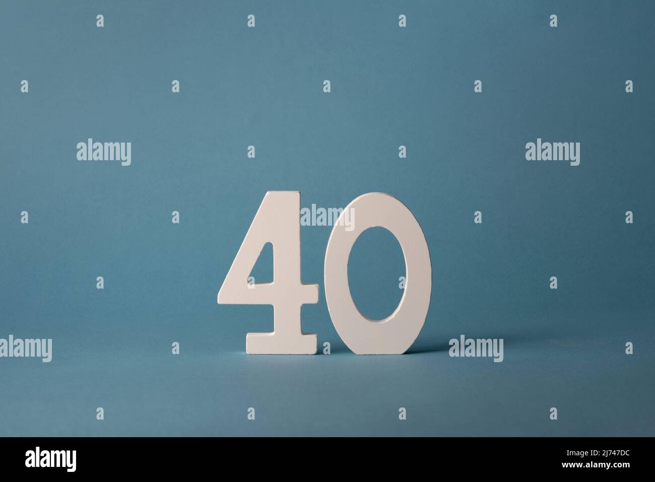White wooden number forty 40 on blue background Stock Photo - Alamy