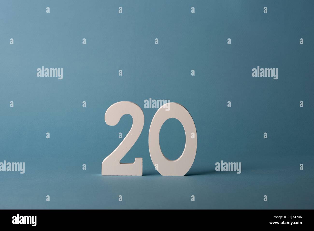 White wooden number twenty 20 on blue background Stock Photo - Alamy