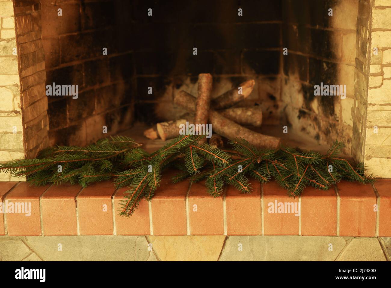 Fireplace with firewood and fir twigs without fire Stock Photo - Alamy