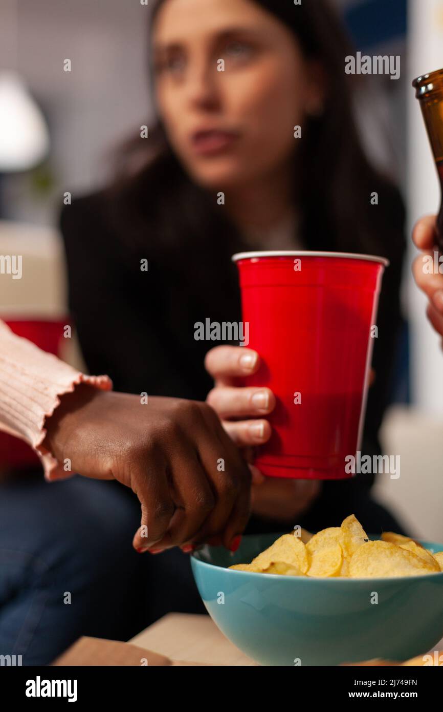 Office workers having fun with alcoholic beverage and chips at after ...