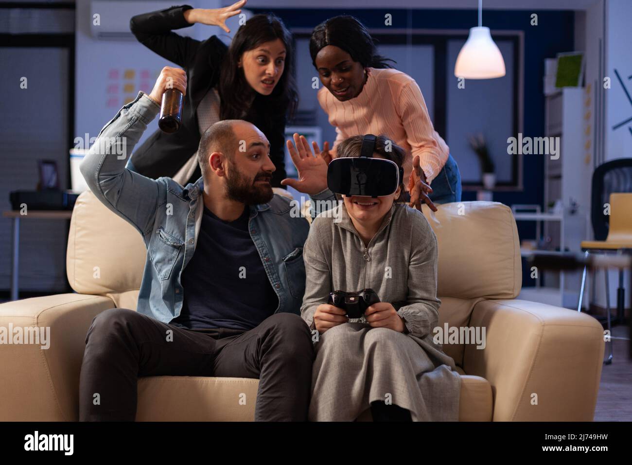 Multiethnic group of colleagues playing video games with vr glasses at ...